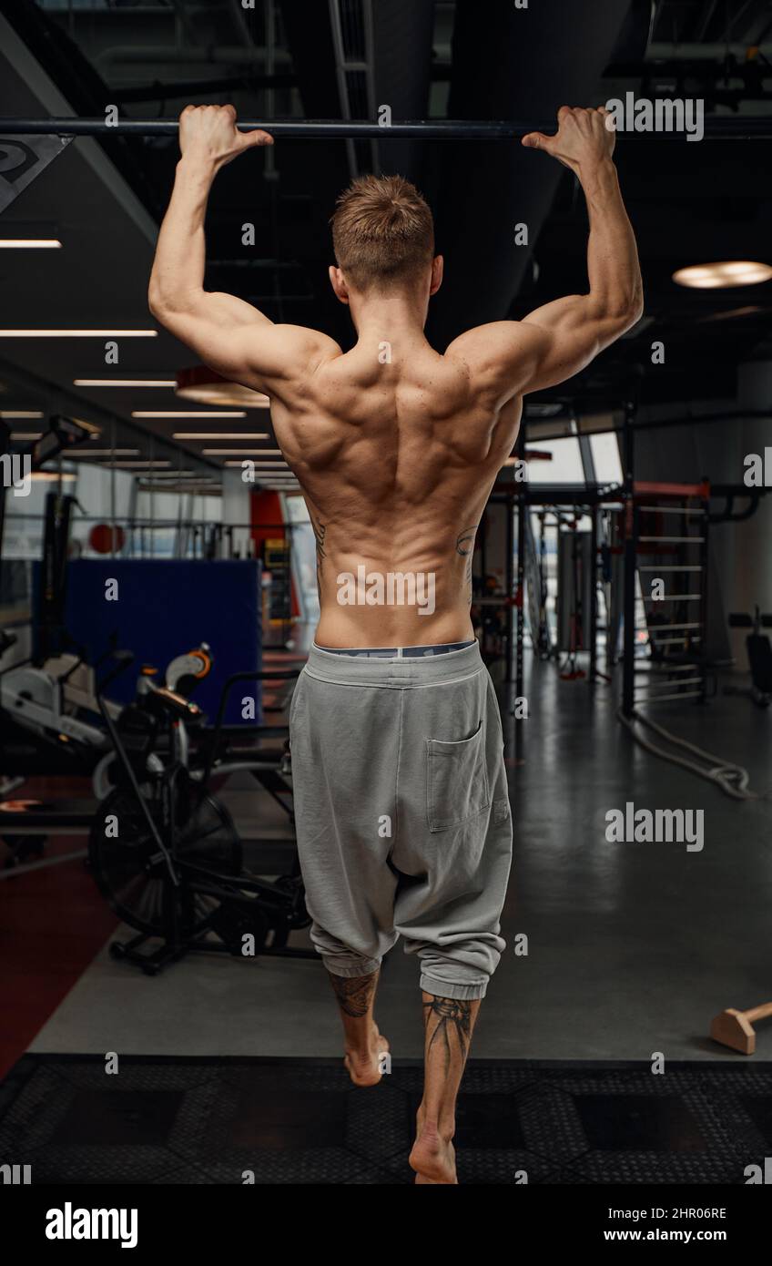 Muscular strong man exercising in the sport gym, Man doing horizontal ...