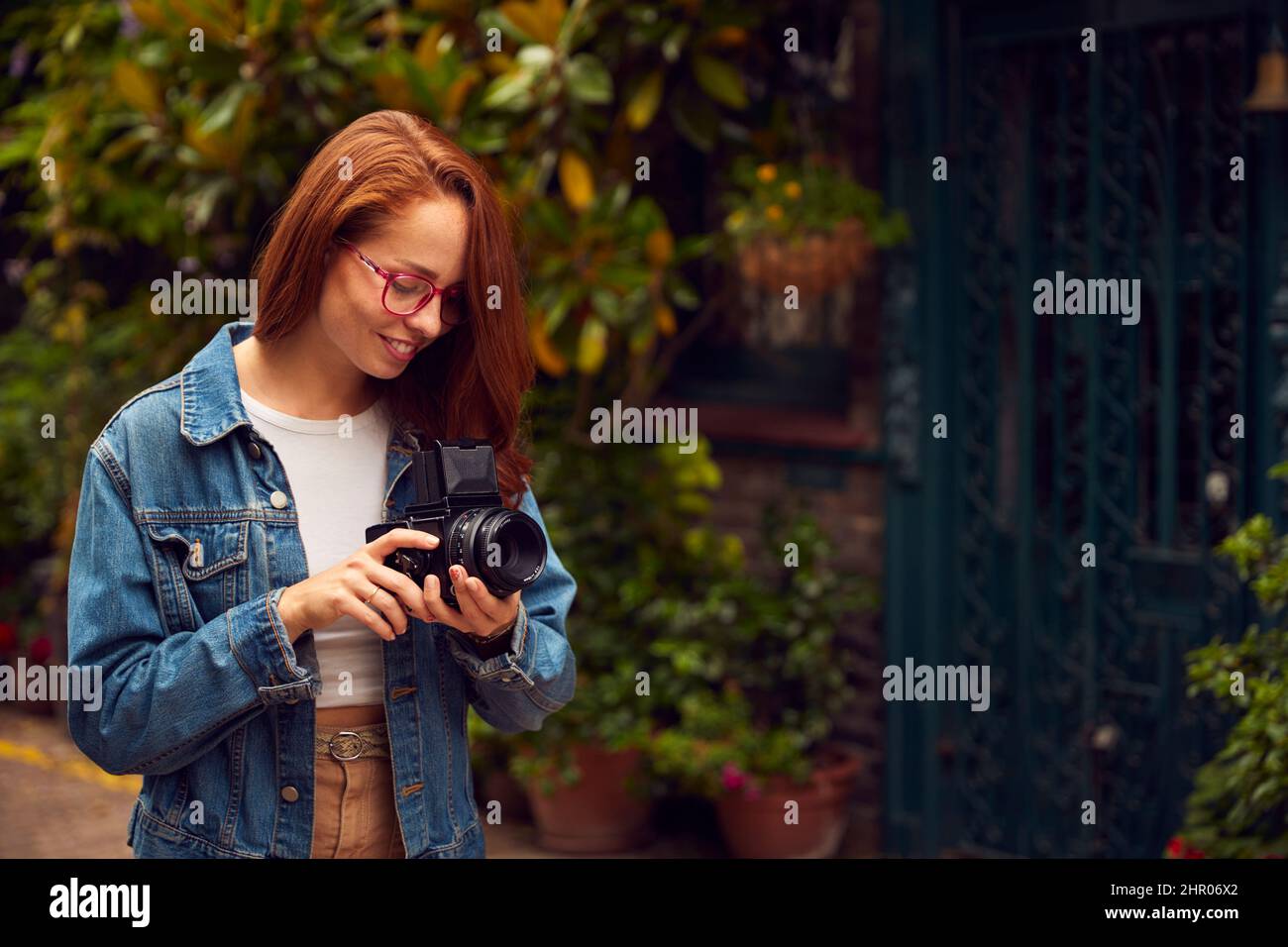 Young Woman In City Taking Photo On Retro Medium Format Film Camera To ...