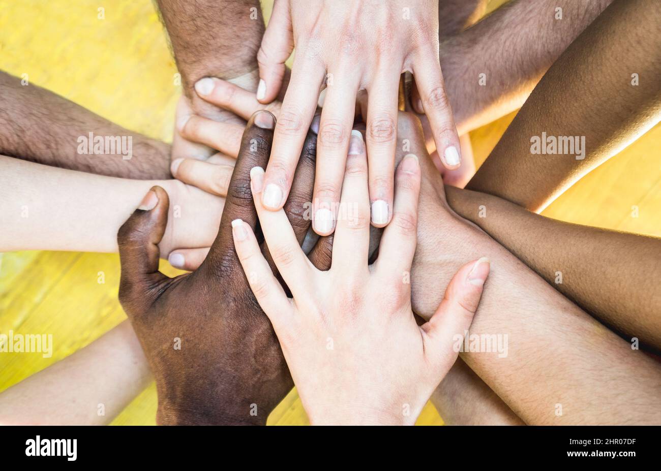Top view of multiracial stacking hands - International friendship ...