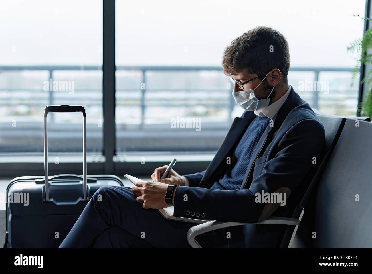 passenger in a protective mask taking notes in his diary Stock Photo ...
