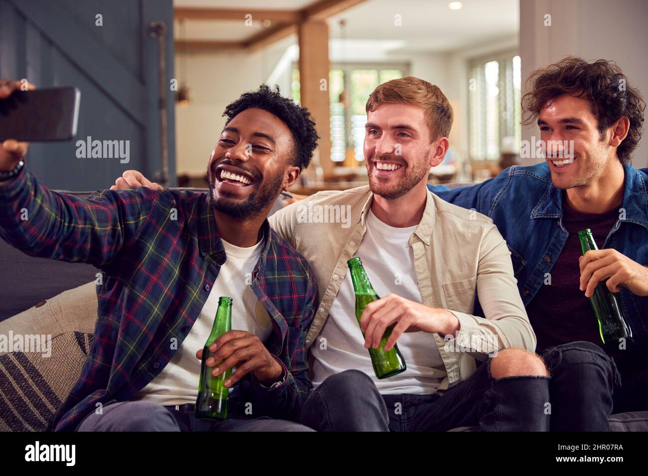 Multi-Cultural Group Of Male Friends Sitting On Sofa At Home Posing For ...