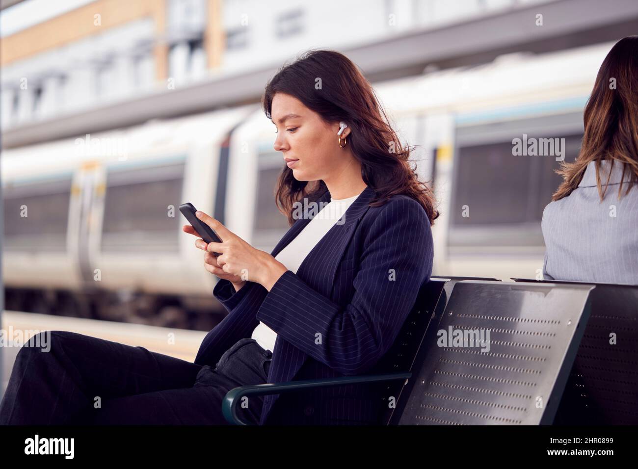 Two Businesswomen Commuting To Work Waiting For Train On Station ...