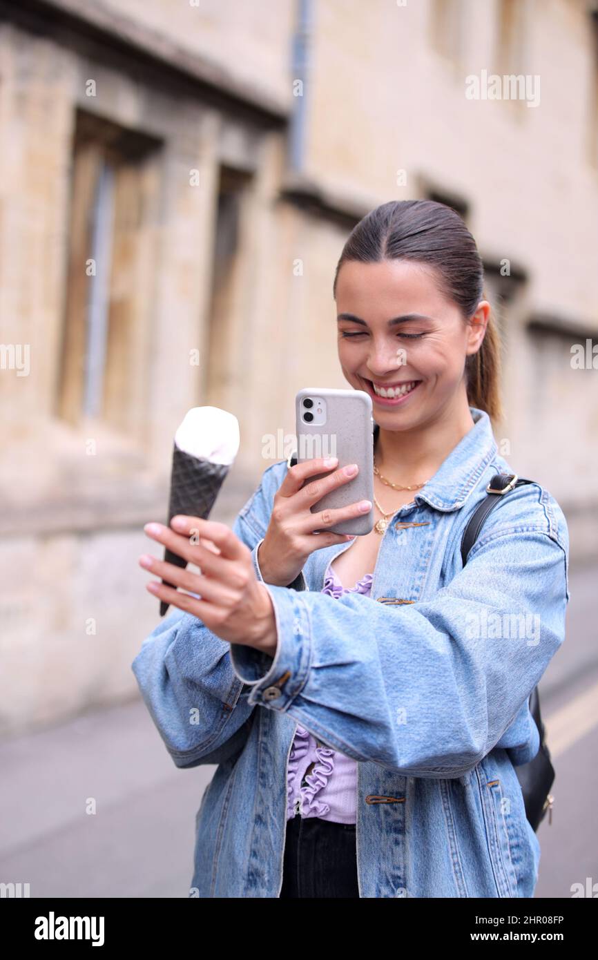 Young Woman Taking Photo Of Ice Cream Cone With Mobile Phone To Post On ...