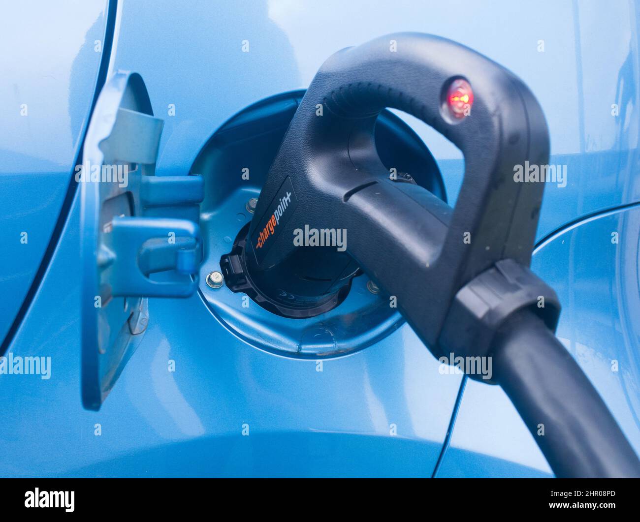 Close up of a ChaDeMo charging nozzle inserted into blue electric ...