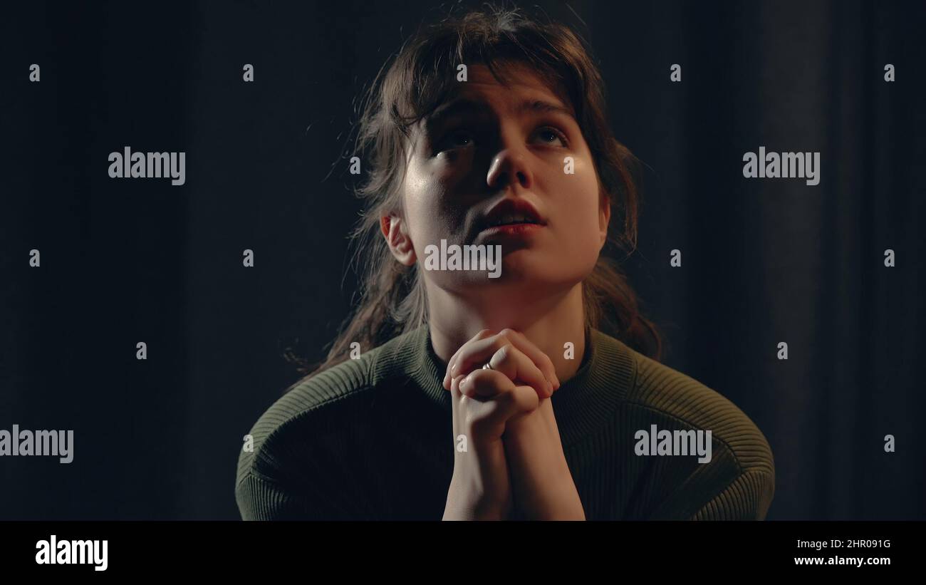 Praying woman in dark room hi-res stock photography and images - Alamy