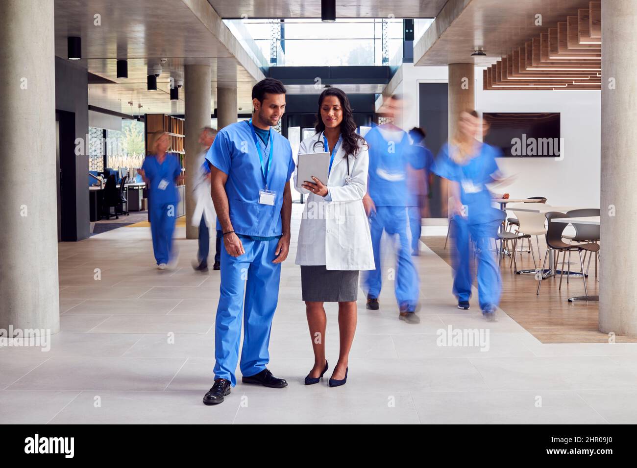 Male And Female Doctors In White Coat And Scrubs Looking At Digital ...