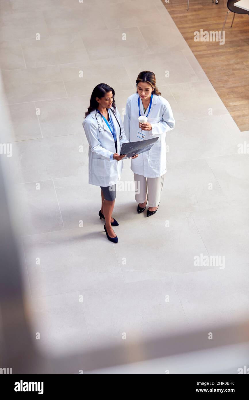 Overhead Shot Of Two Female Medical Staff In White Coats Discussing ...