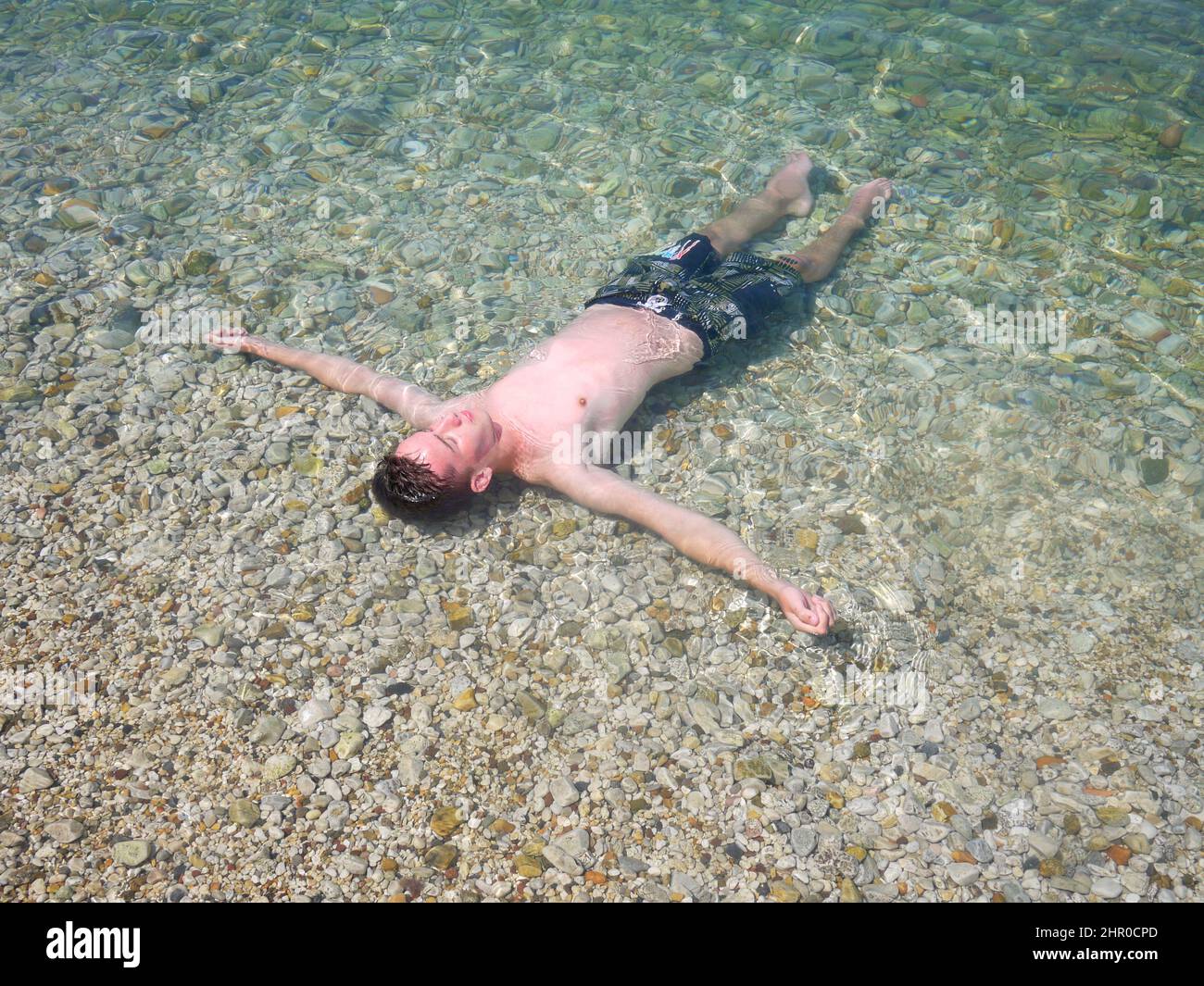 Boy floating on the beach Stock Photo - Alamy
