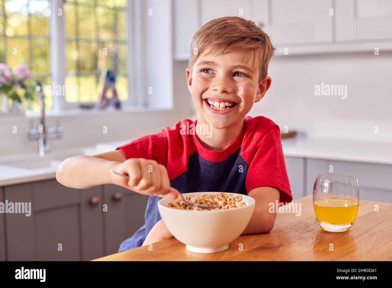 Boy At Home Eating Bowl Of Breakfast Cereal At Kitchen Counter Stock ...