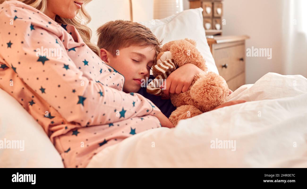 Mother Cuddling Sleeping Son In Bed Holding Toy Teddy Bear Stock Photo ...