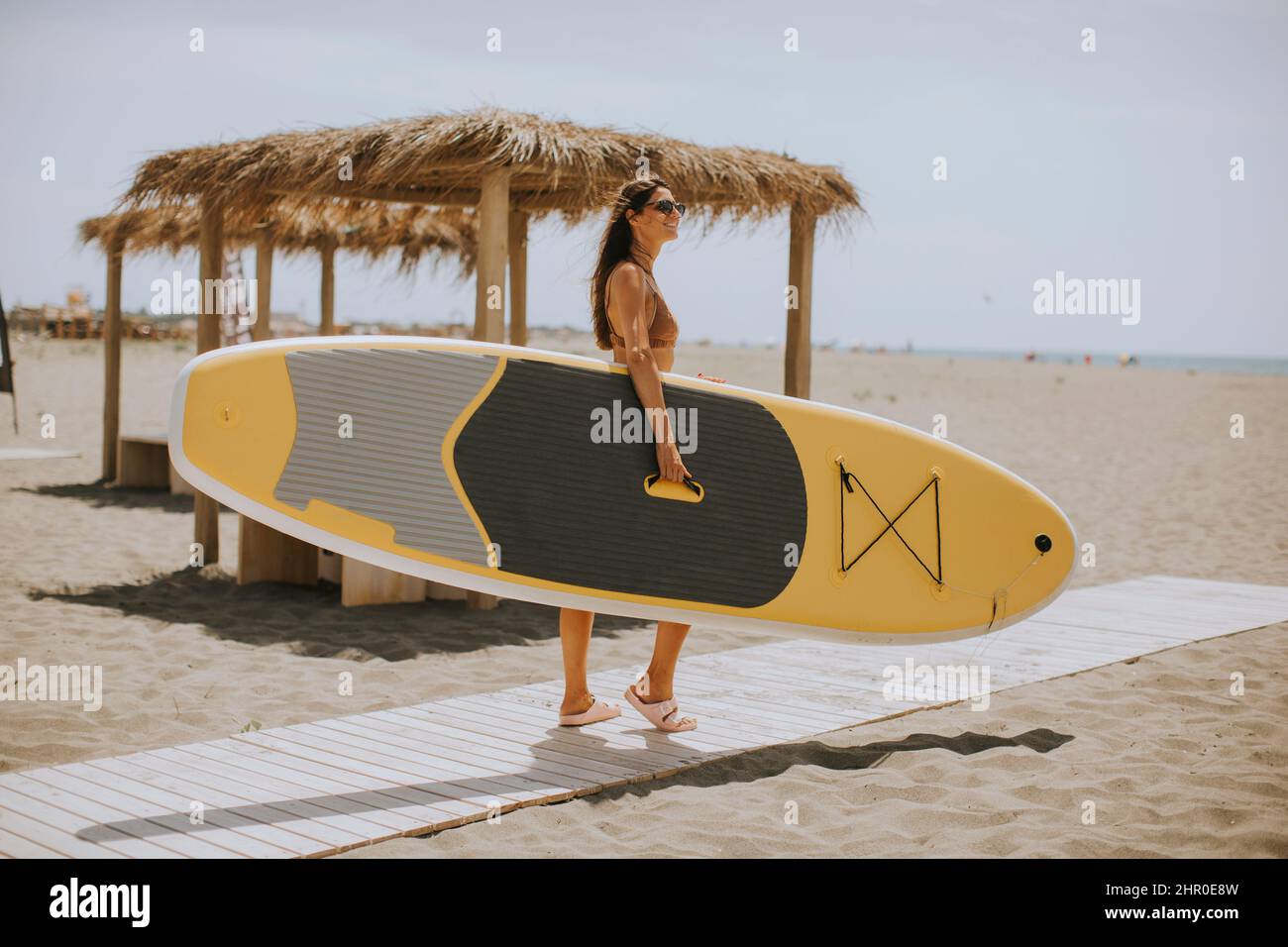 Pretty young woman with paddle board on the beach on a summer day Stock ...