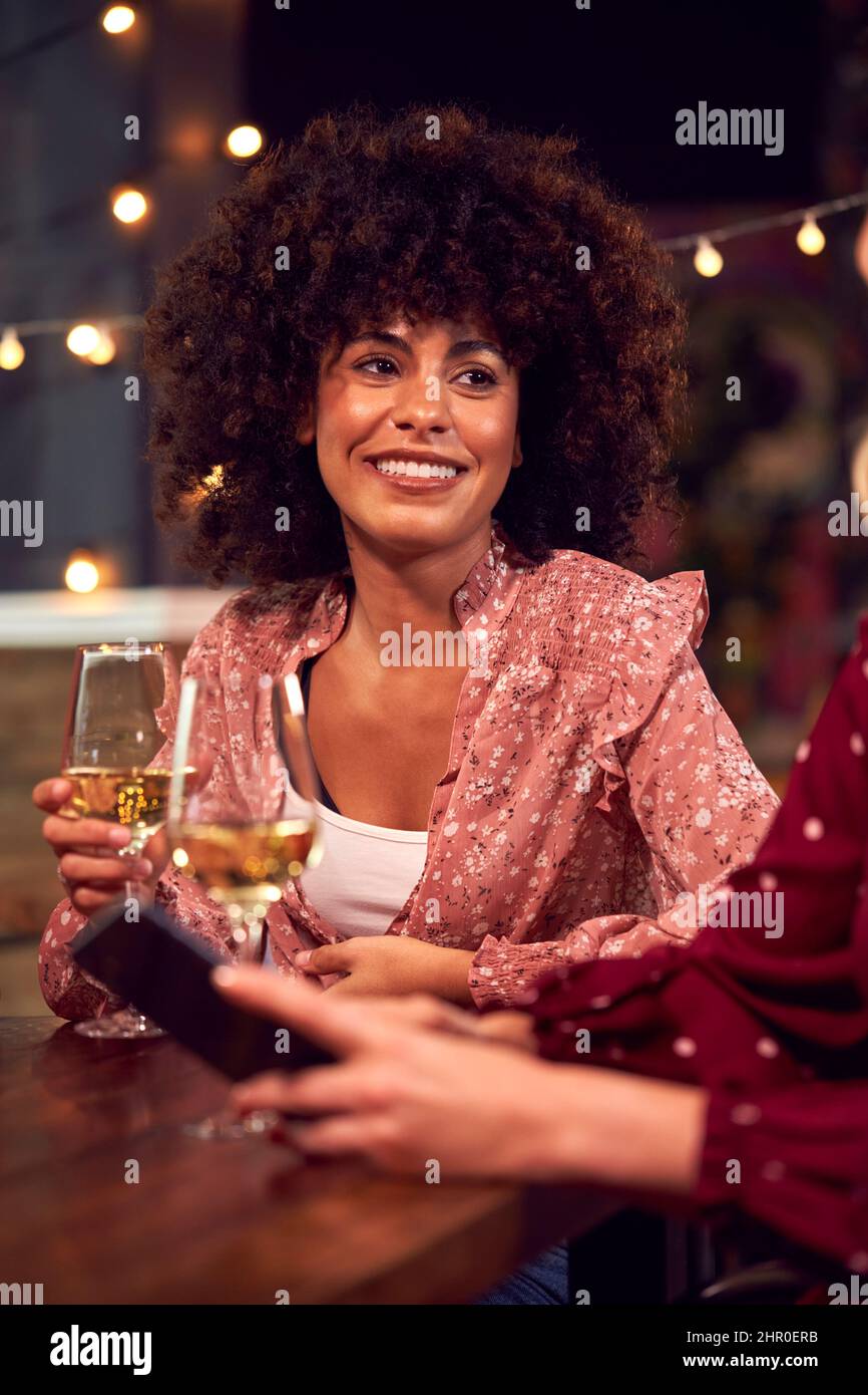 Female Friends Meeting And Talking At Table In Bar Stock Photo - Alamy