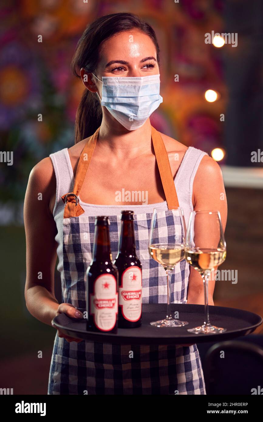 Portrait Of Female Server Wearing Face Mask Holding Tray Of Drinks In ...