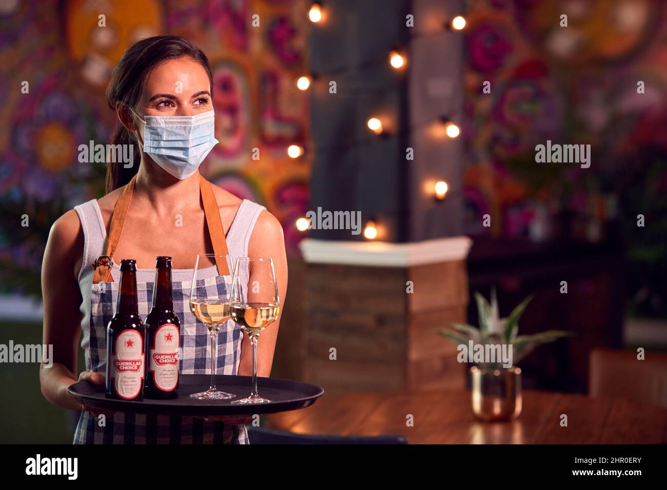Portrait Of Female Server Wearing Face Mask Holding Tray Of Drinks In ...
