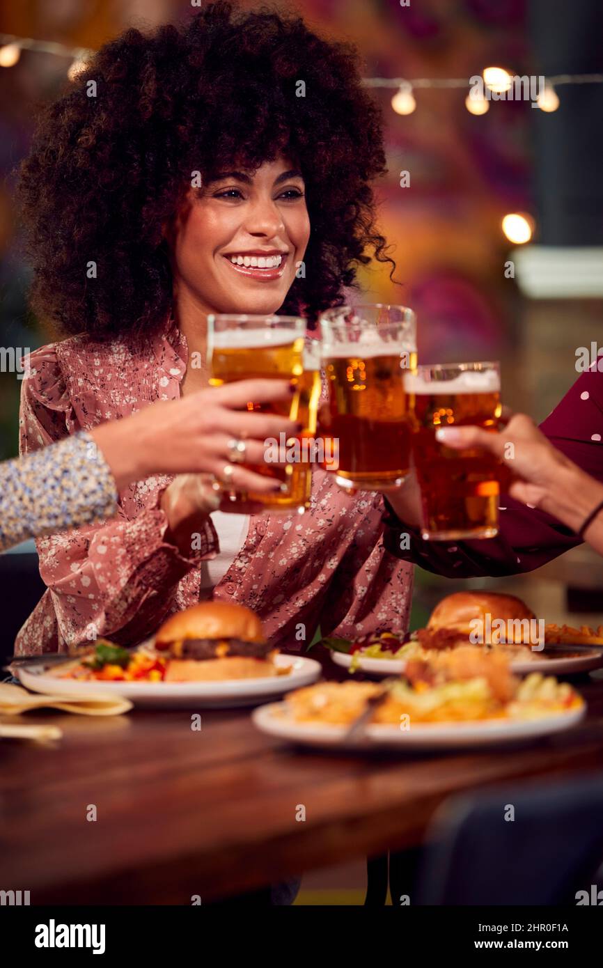 Multi-Cultural Group Of Female Friends Enjoying Night Out Eating Meal ...