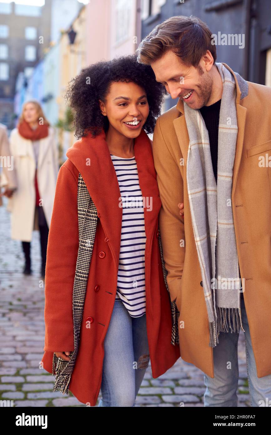 Multi Cultural Couple With Friends Walking Along Residential City ...