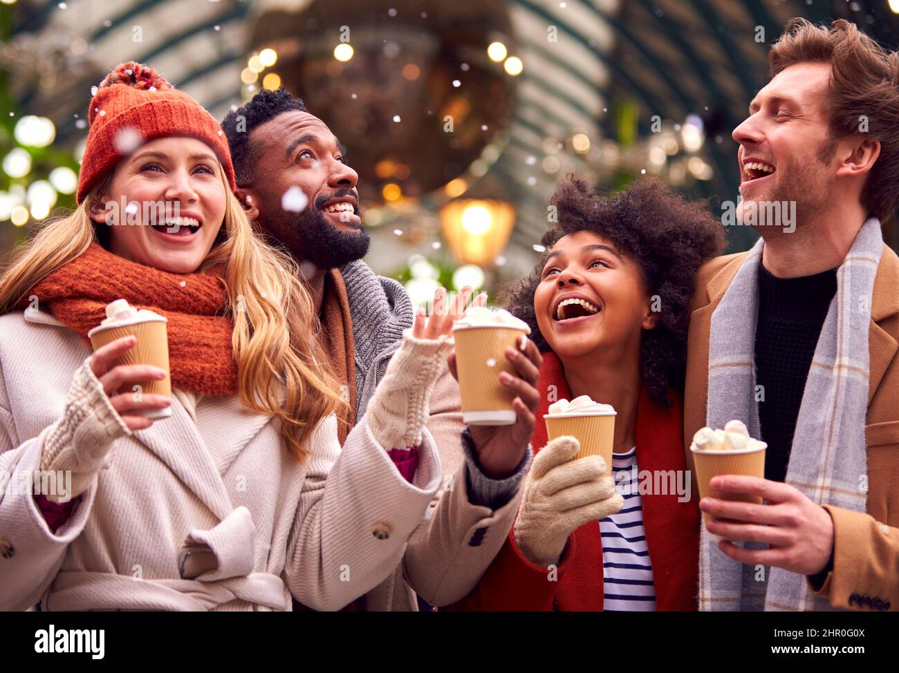 Group Of Friends Drinking Hot Chocolate With Marshmallows In Snow At ...