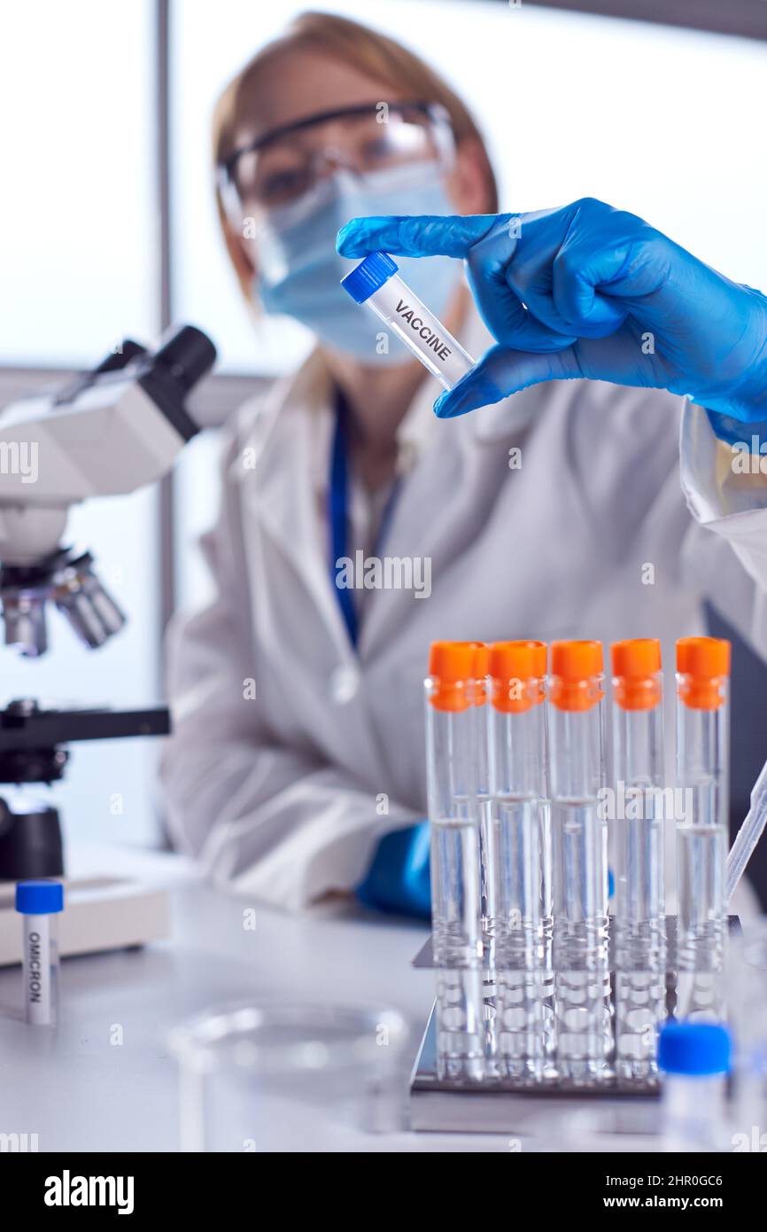 Female Lab Worker Wearing PPE Researching Vaccine In Laboratory With ...
