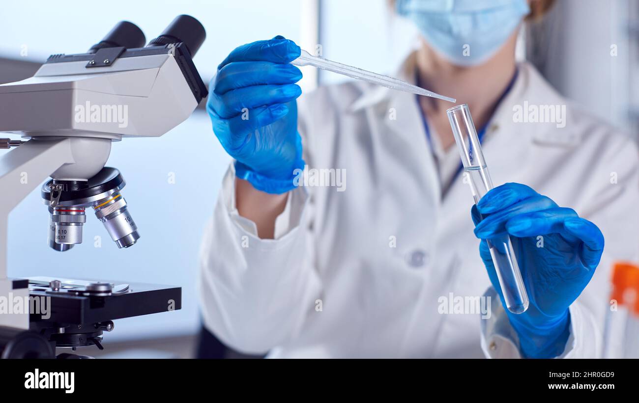 Close Up Of Female Lab Worker Wearing White Coat Using Pipette And Test ...