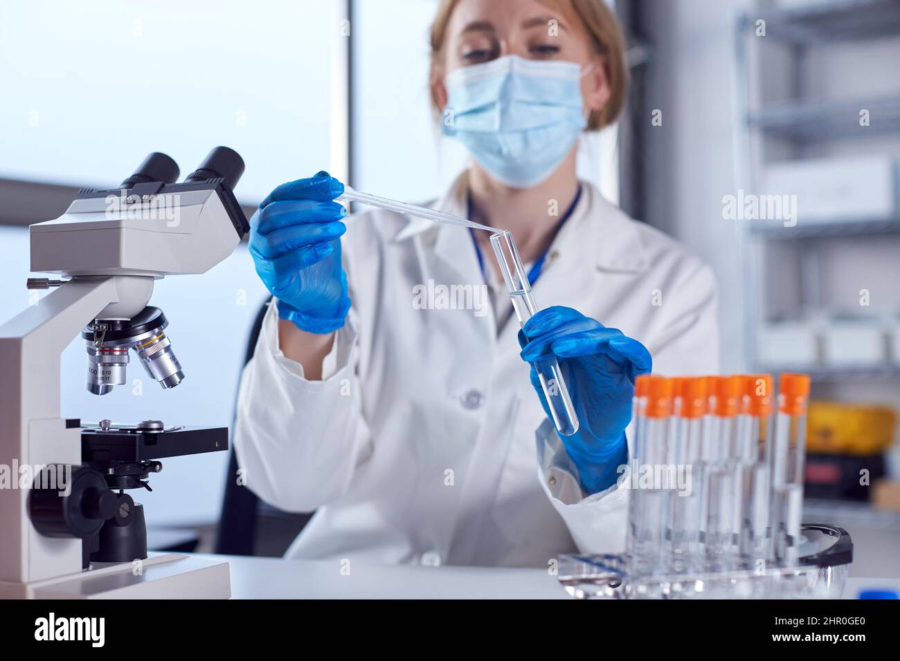 Female Lab Worker Wearing White Coat Using Pipette And Test Tube In ...