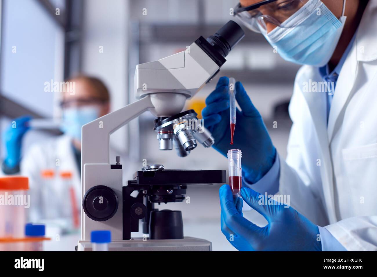 Two Female Lab Workers Wearing PPE Testing Blood Samples In Laboratory ...