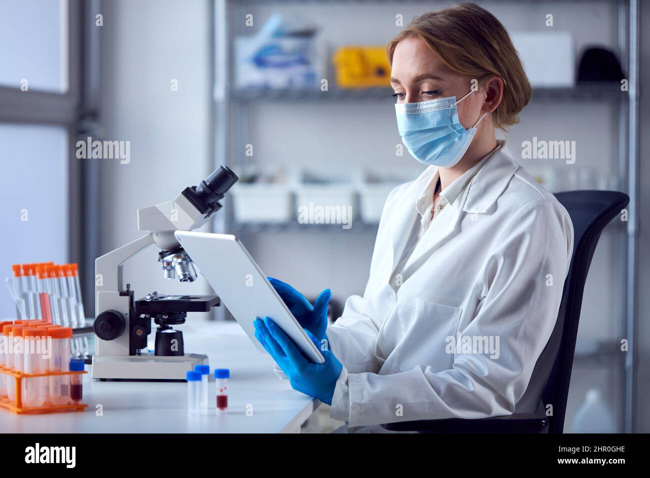 Female Lab Worker Wearing Lab Coat Working On Covid-19 Vaccine With ...