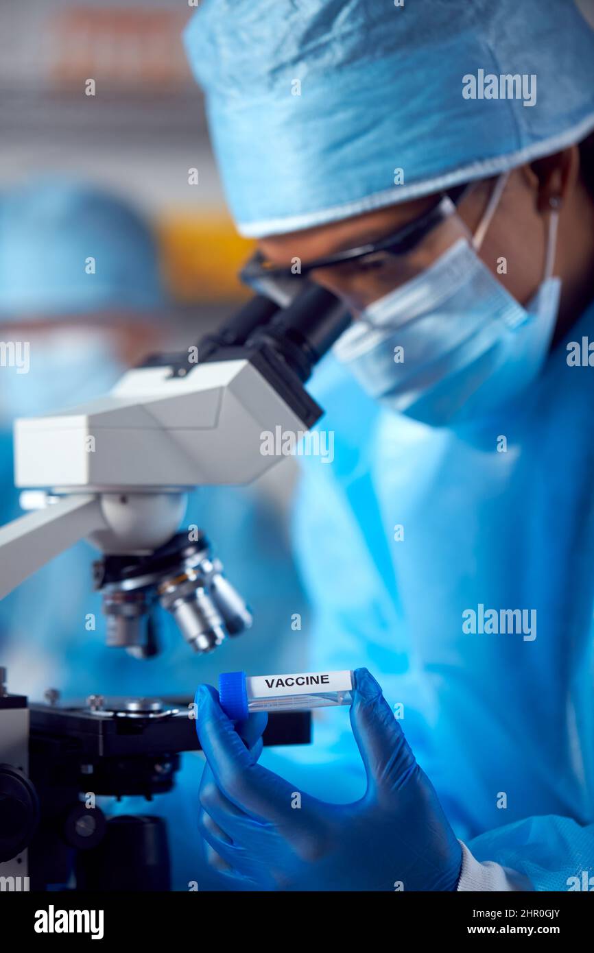 Close Up Of Female Lab Worker Wearing PPE Researching Vaccine With ...