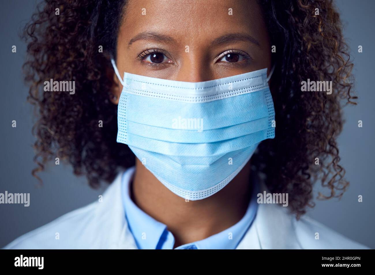 Close Up Studio Portrait Of Female Doctor in PPE With Face Mask Looking ...