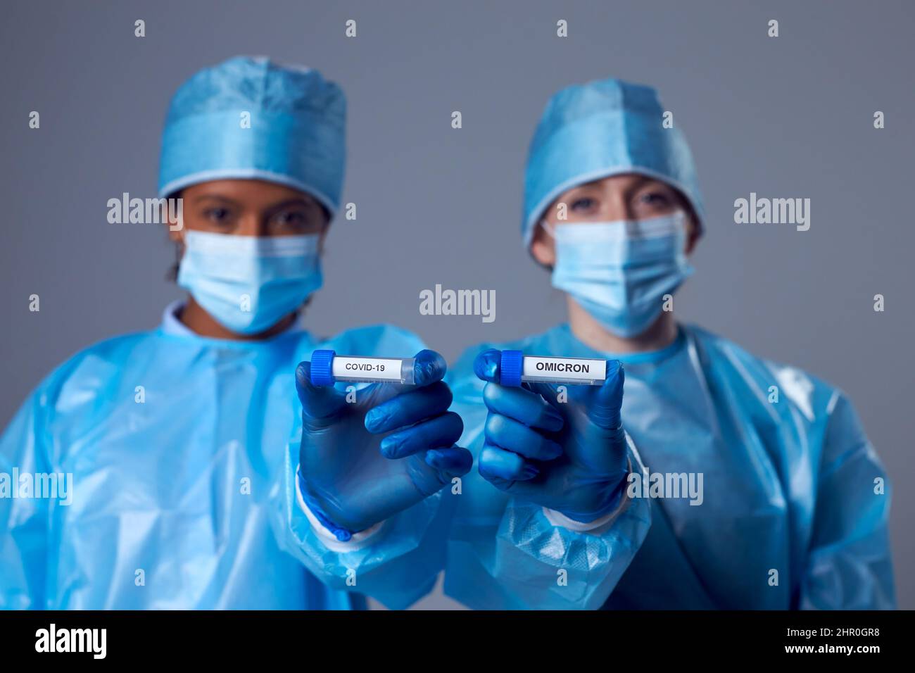 Two Female Lab Research Workers In PPE Holding Test Tubes Labelled ...
