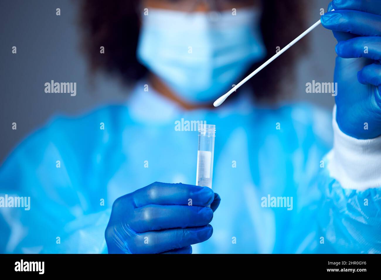 Female Lab Worker In PPE With Safety Glasses And Face Mask Holds Swab ...