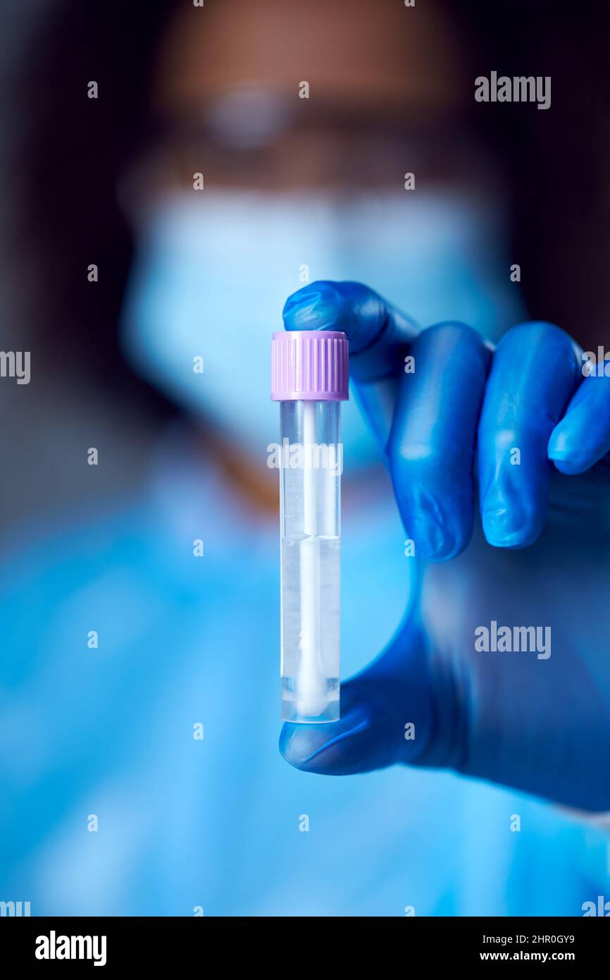 Female Lab Worker In PPE With Safety Glasses And Face Mask Holding ...