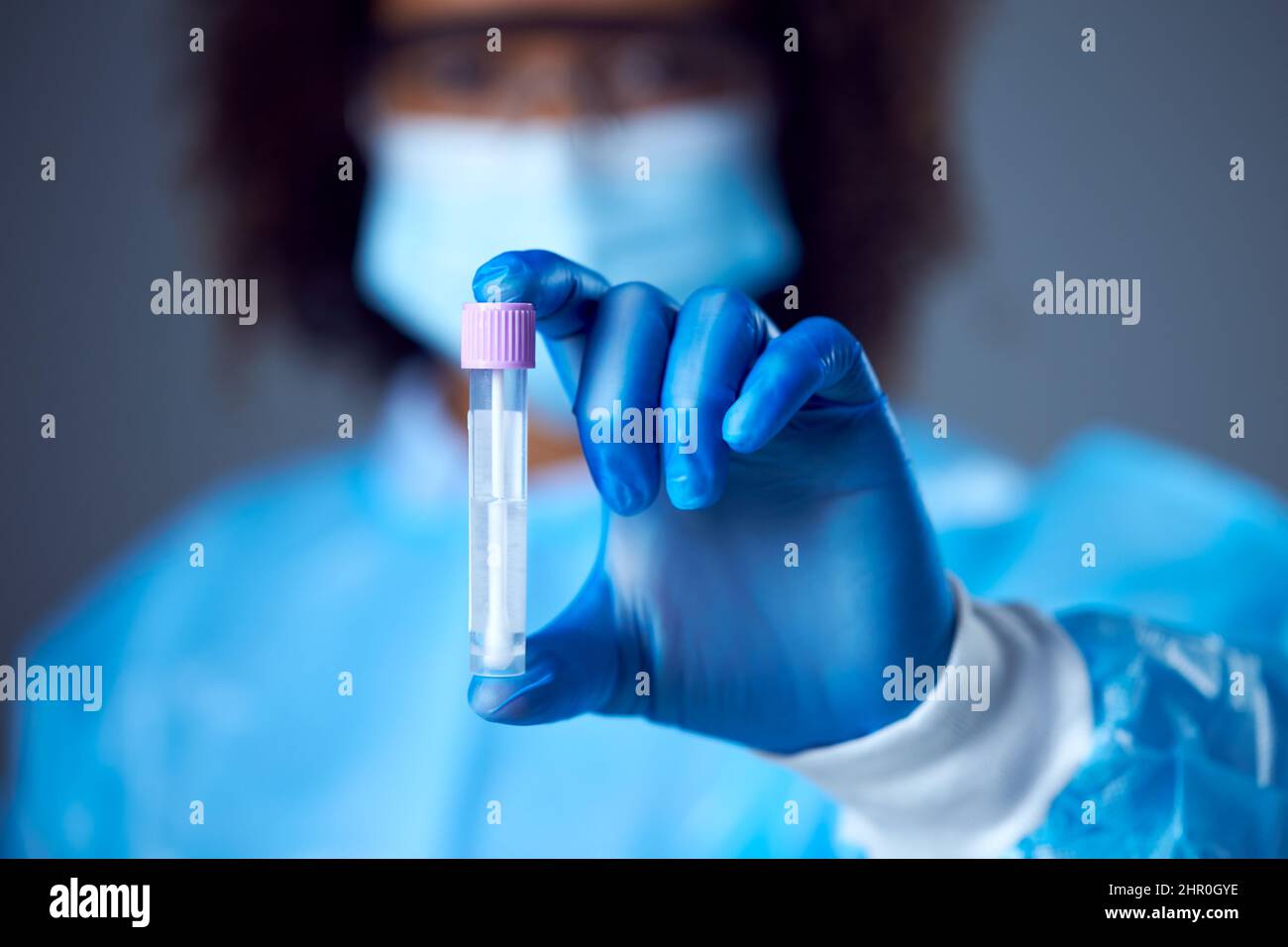 Female Lab Worker In PPE With Safety Glasses And Face Mask Holding Test ...
