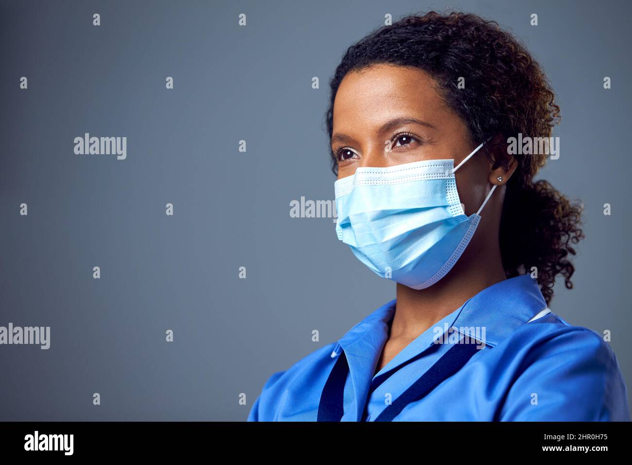 Studio Portrait Of Female Nurse Wearing Uniform And Face Mask Stock ...