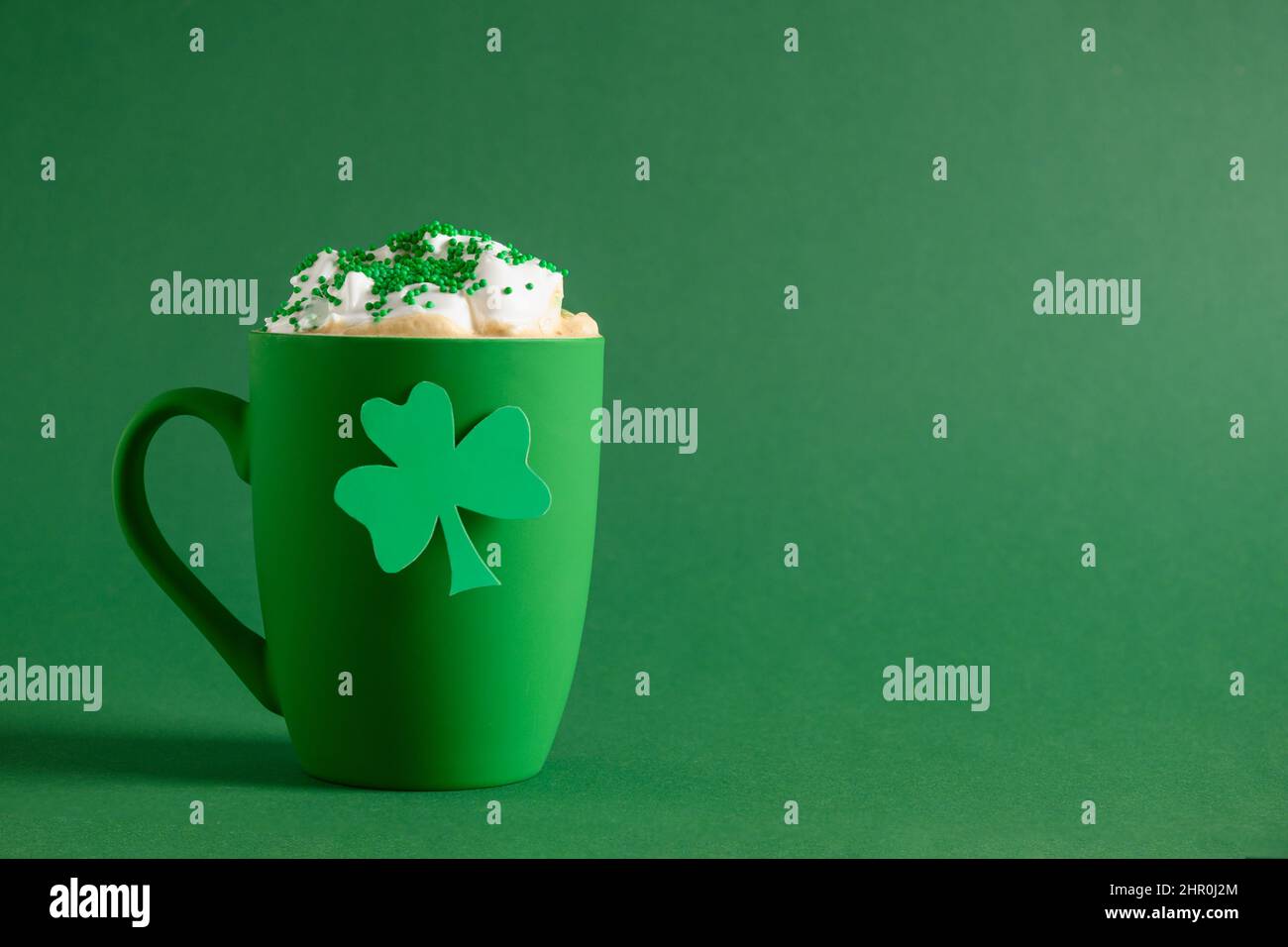 Irish coffee in green cup with whipped cream and sprinkles for St ...