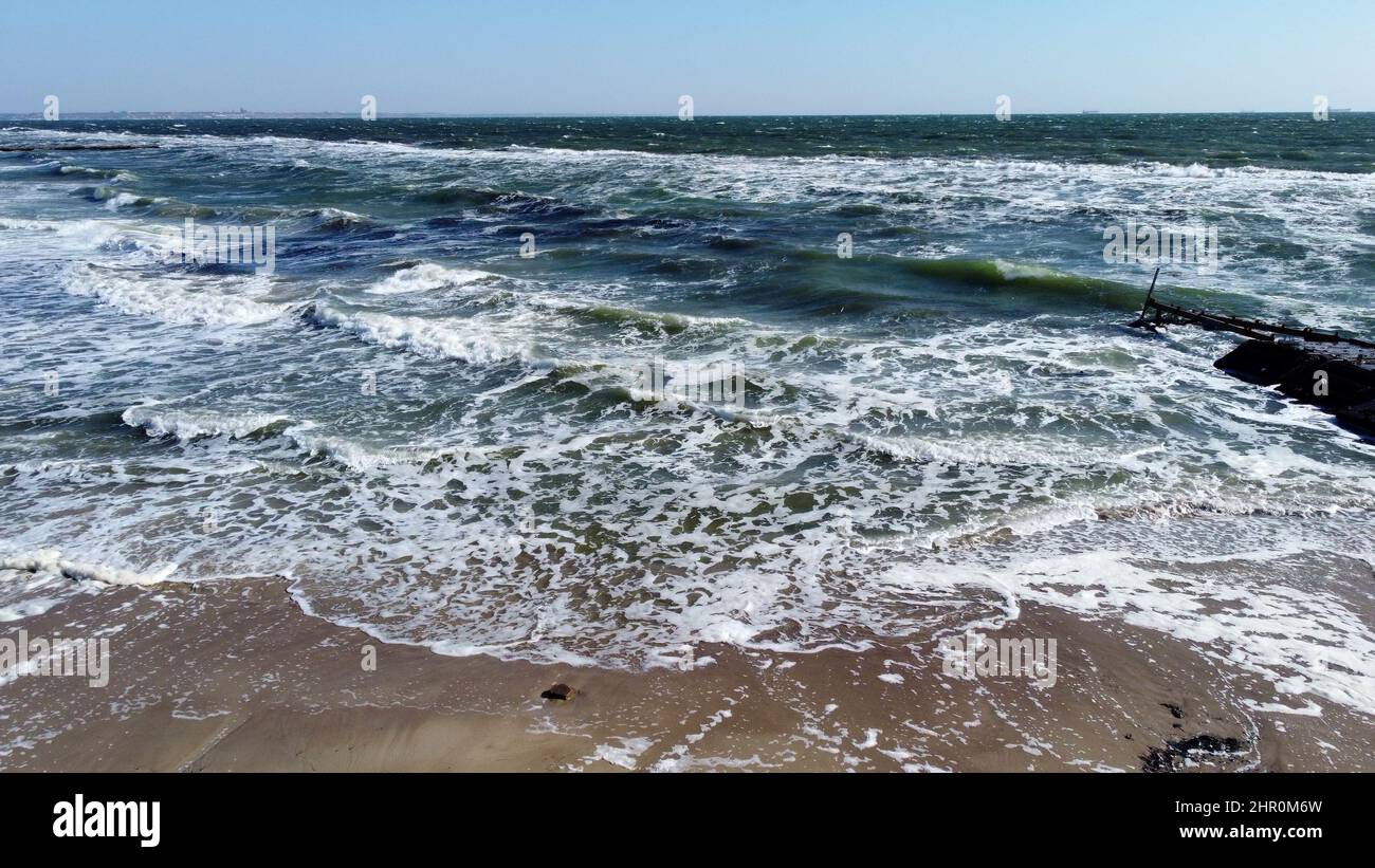Aerial drone view flight over waves that roll onto the sandy shore. Top ...