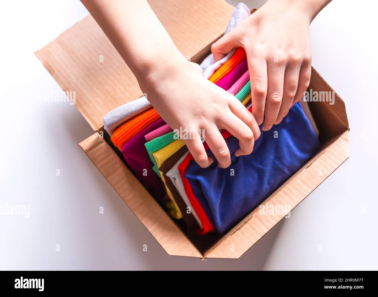 Folded colorful clothes in the box. Home organizing. Domestic vertical ...