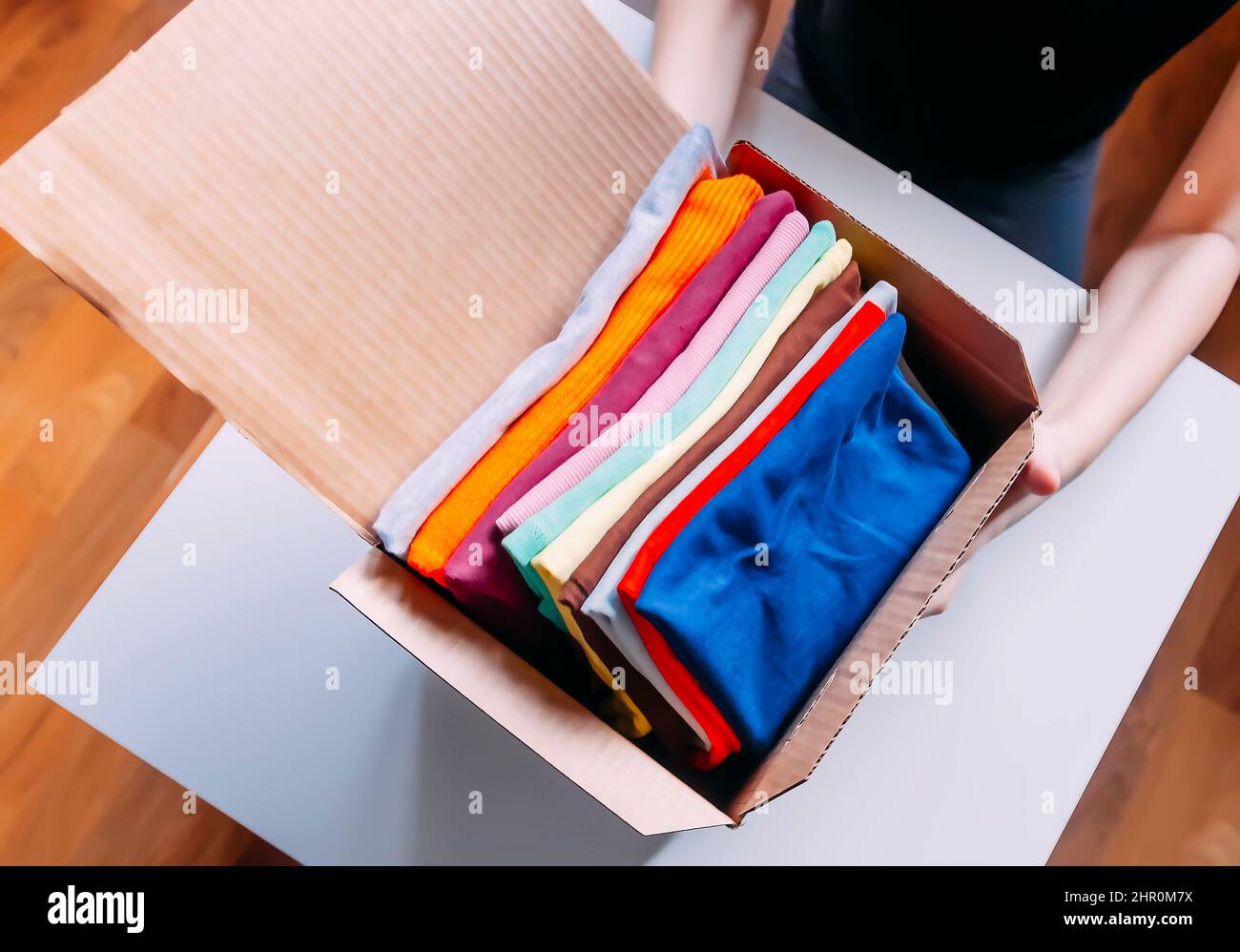 Folded colorful clothes in the box. Home organizing. Domestic vertical ...