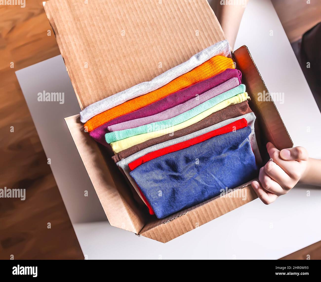 Folded colorful clothes in the box. Home organizing. Domestic vertical ...