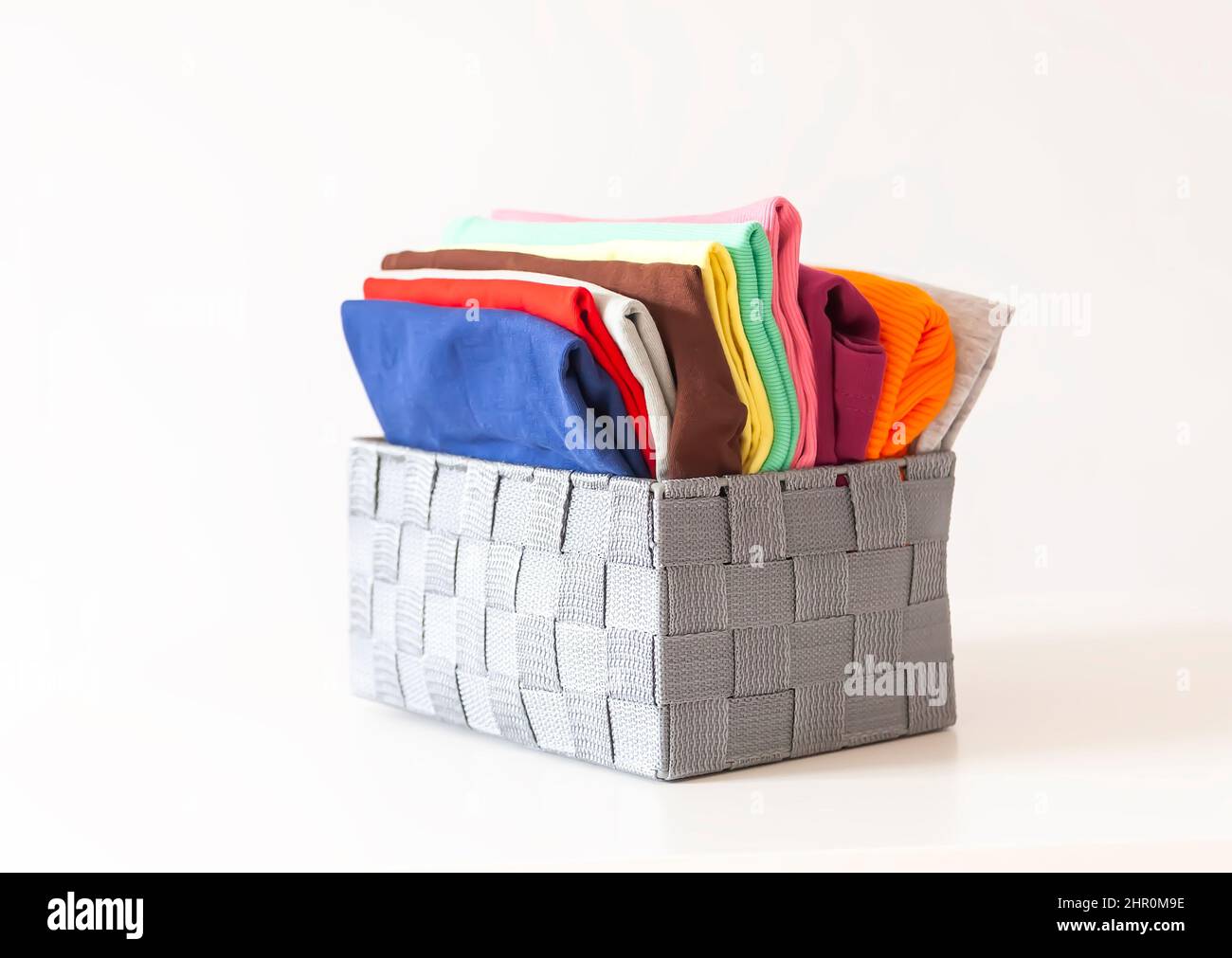 Folded colorful clothes in the box. Home organizing. Domestic vertical ...