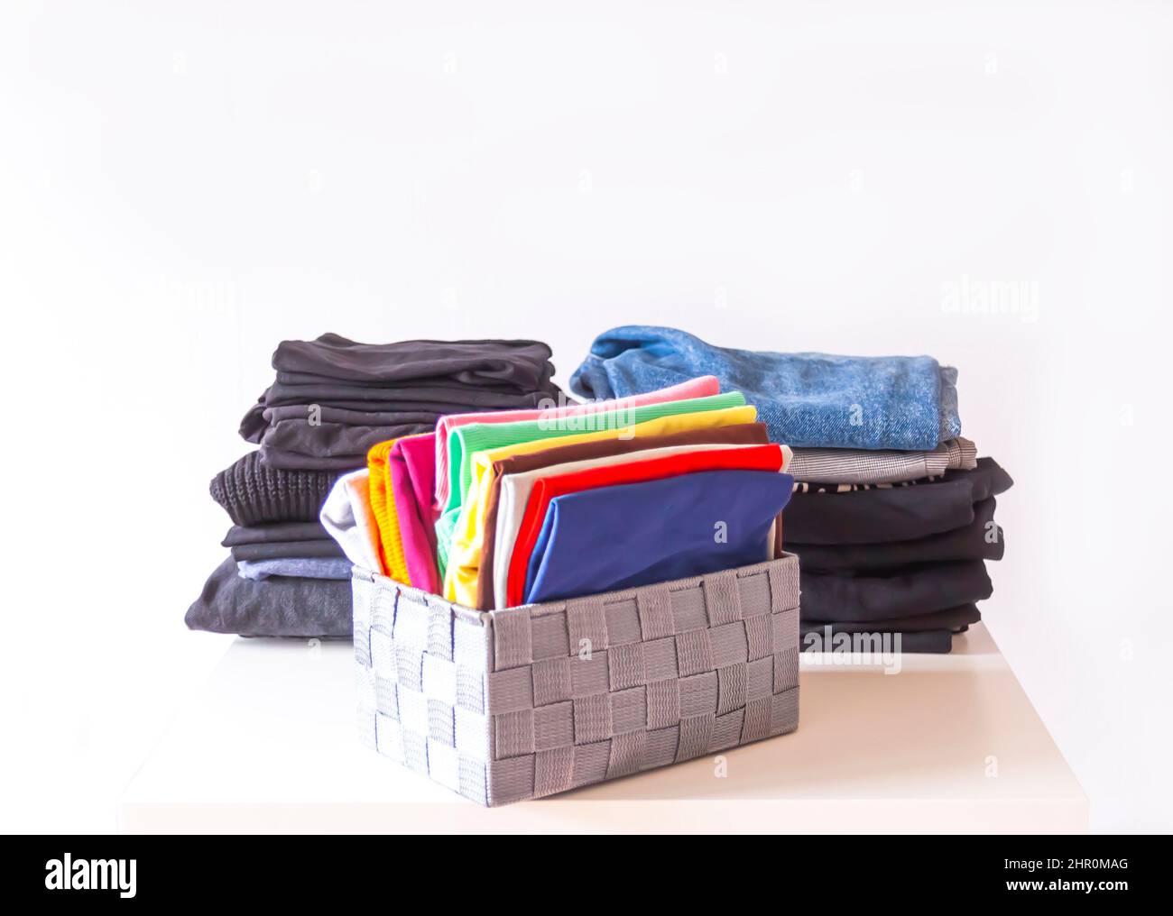 Folded colorful clothes in the box. Home organizing. Domestic vertical ...