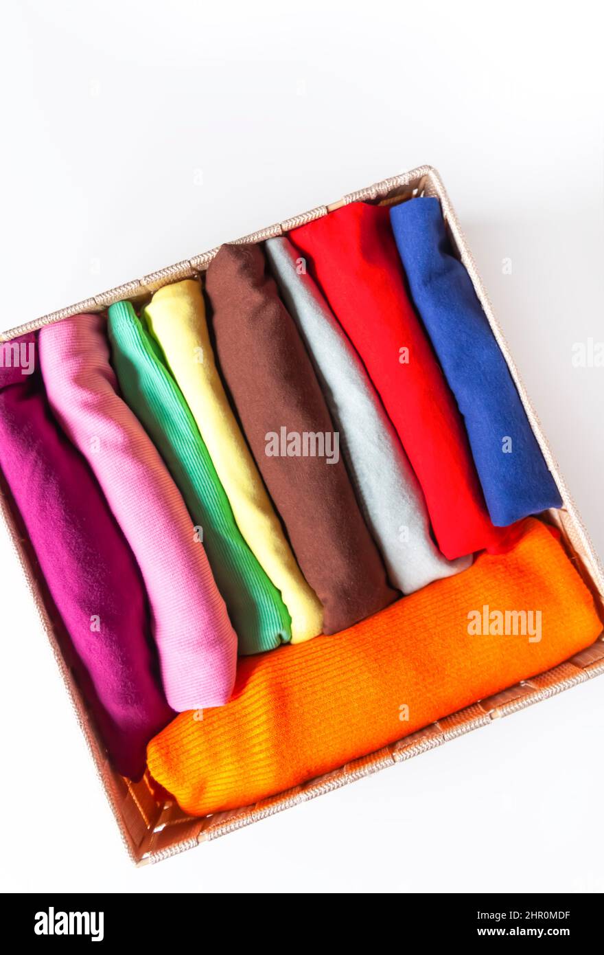 Folded colorful clothes in the box. Home organizing. Domestic vertical ...