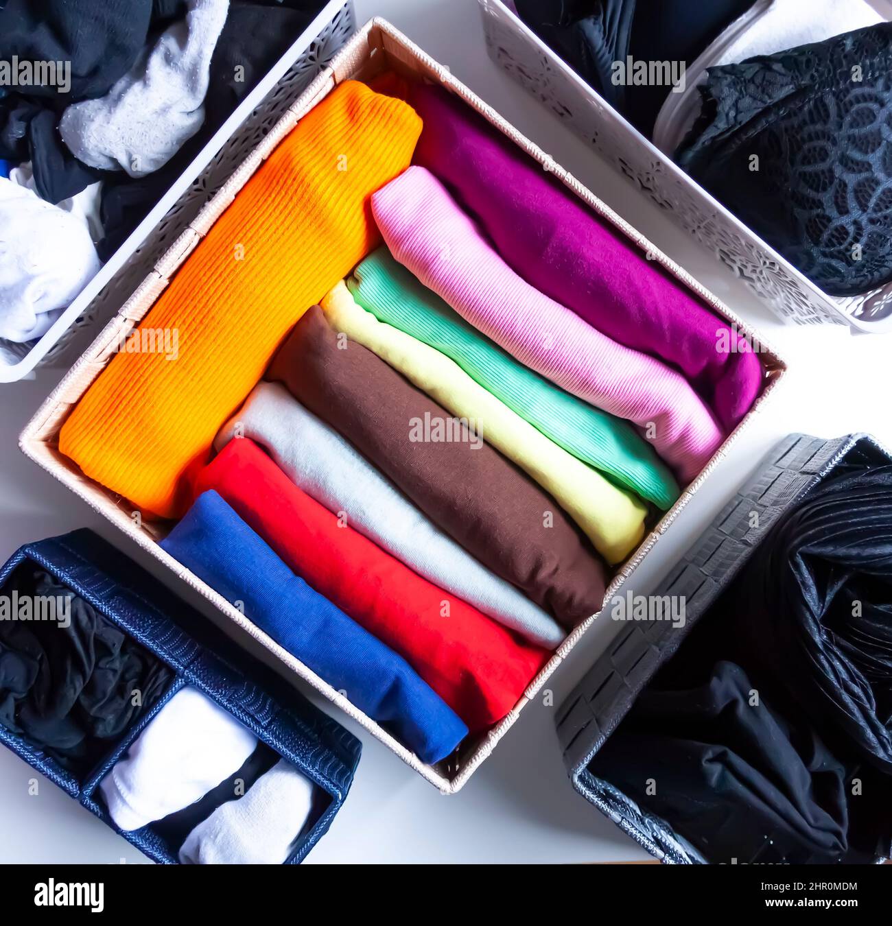 Folded colorful clothes in the box. Home organizing. Domestic vertical ...
