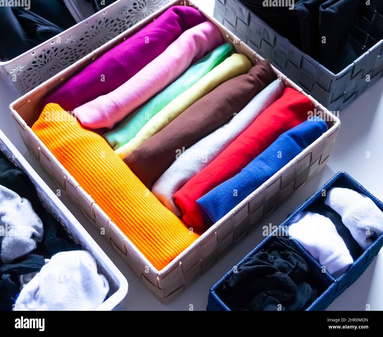 Folded colorful clothes in the box. Home organizing. Domestic vertical ...