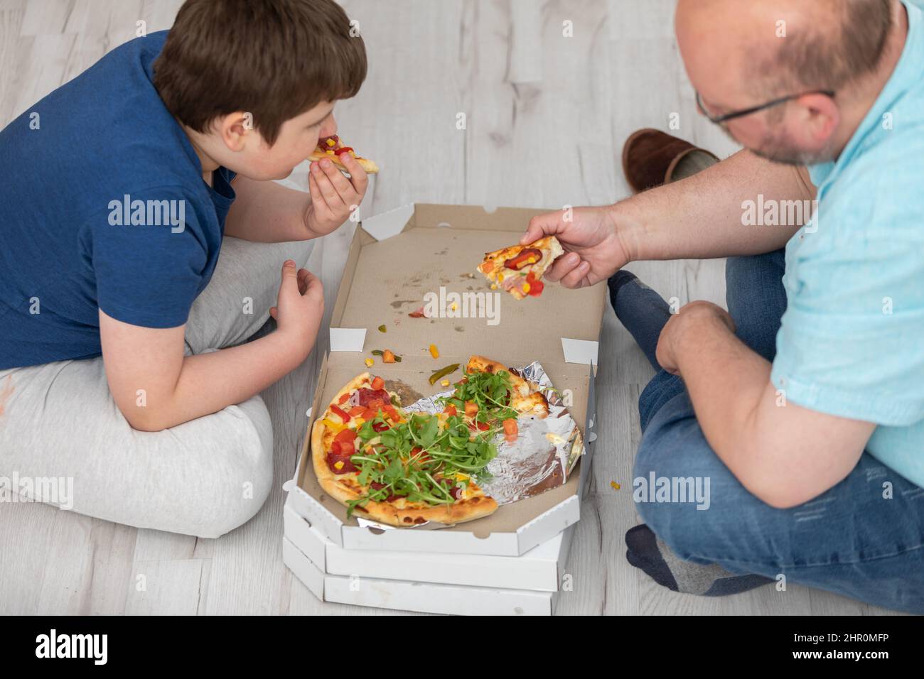 View from above as father and son eat fresh pizza Stock Photo - Alamy