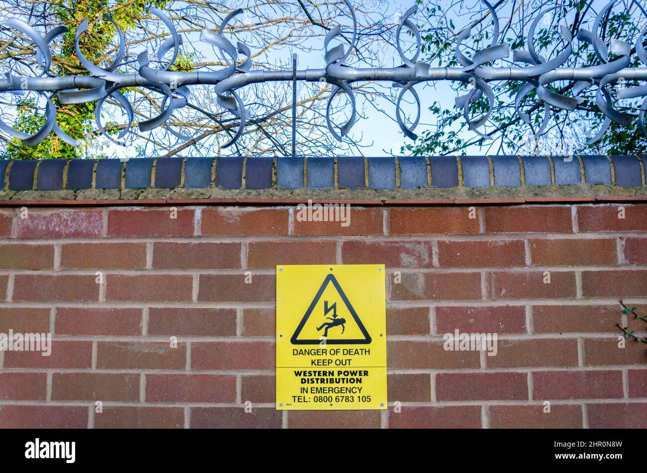 A brick wall around an electrical substation with a climbing deterrent ...