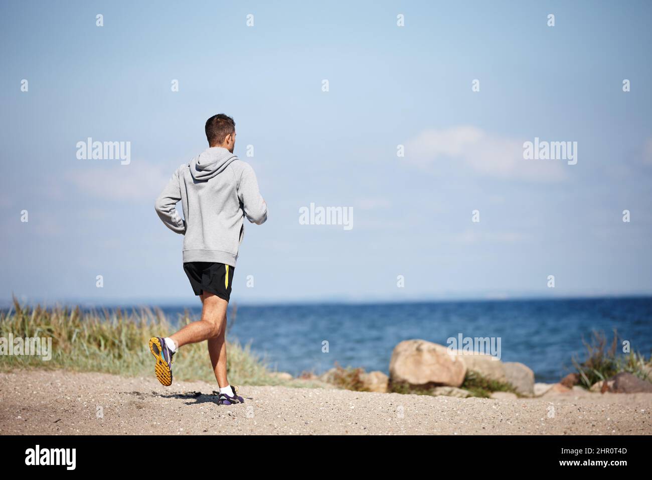 Running towards fitness. Rearview shot of a young man running on the ...