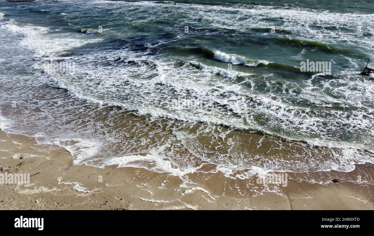 Aerial drone view flight over waves that roll onto the sandy shore. Top ...