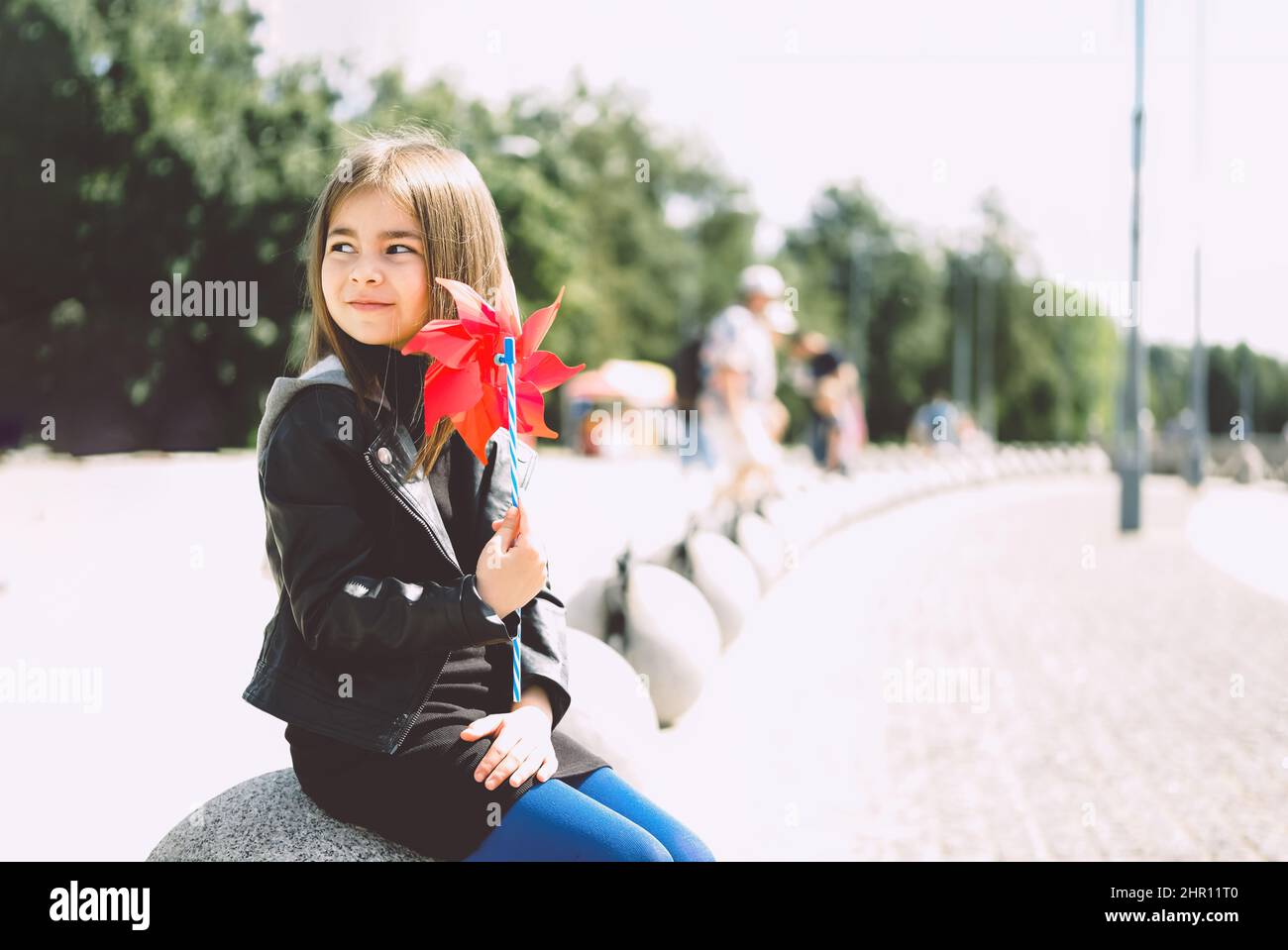 Happy girl with red pinwheel walking outdoors Stock Photo - Alamy