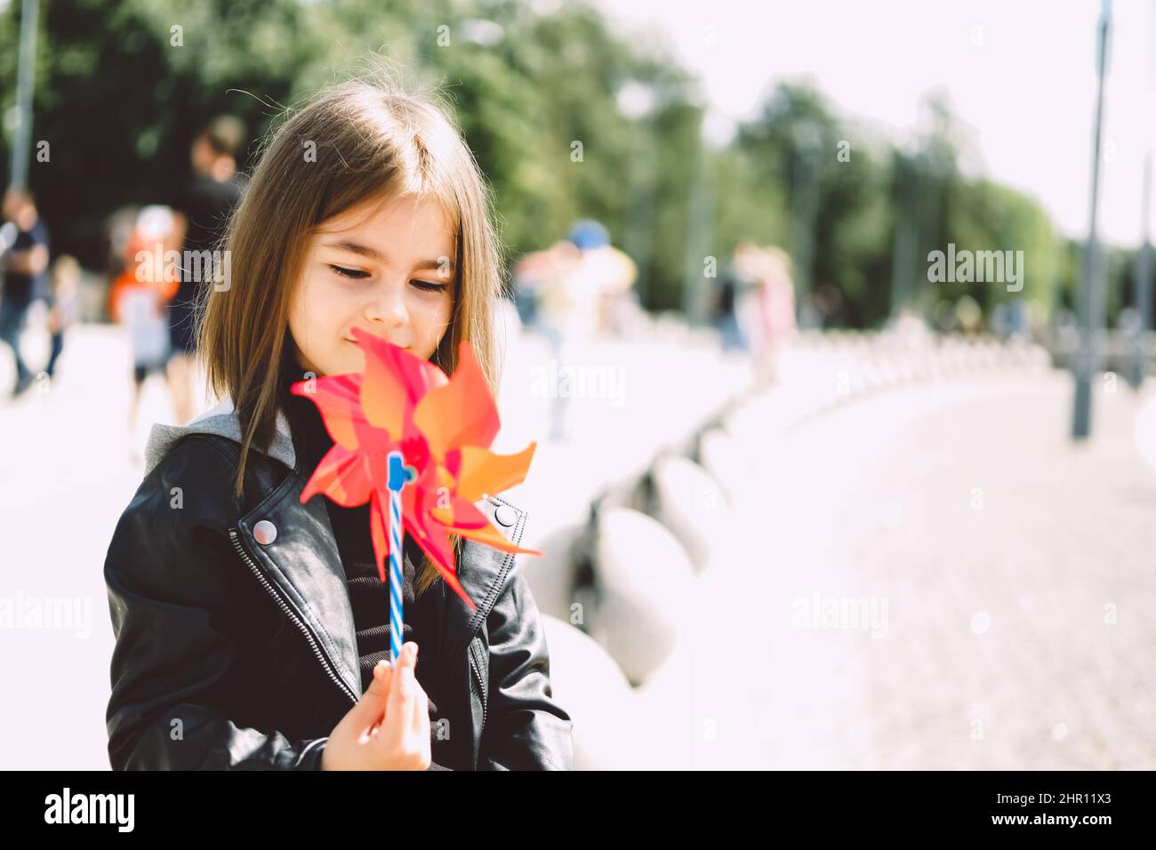 Happy girl with red pinwheel walking outdoors Stock Photo - Alamy