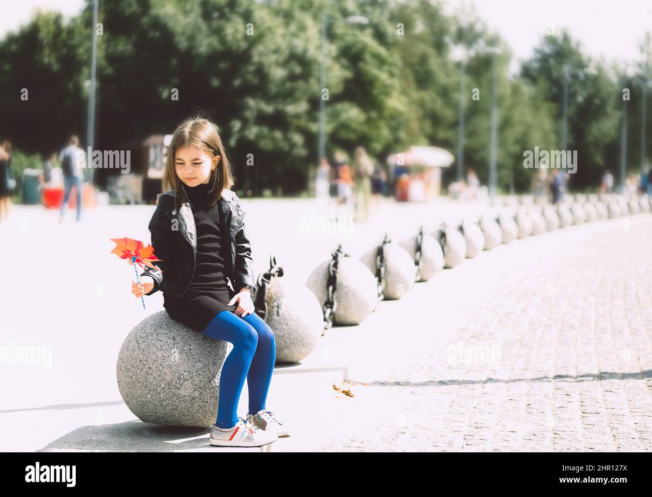 Happy girl with red pinwheel walking outdoors Stock Photo - Alamy